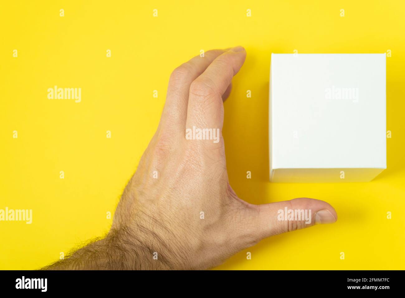 Mens hand takes white cardboard box. Man wants to take box. Copy space ...