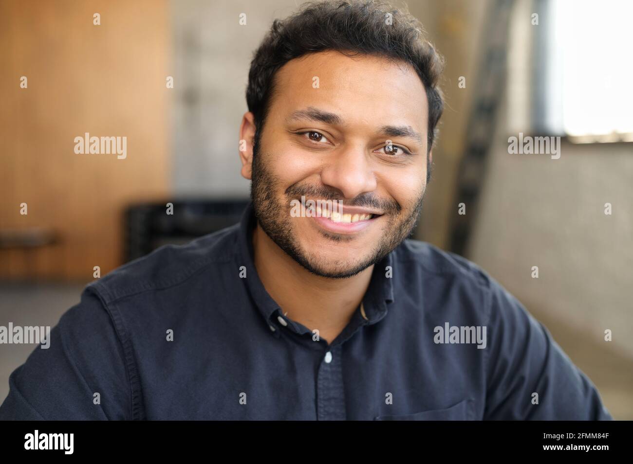 Cheerful and serene hindu man in smart casual shirt, headshot of young ...