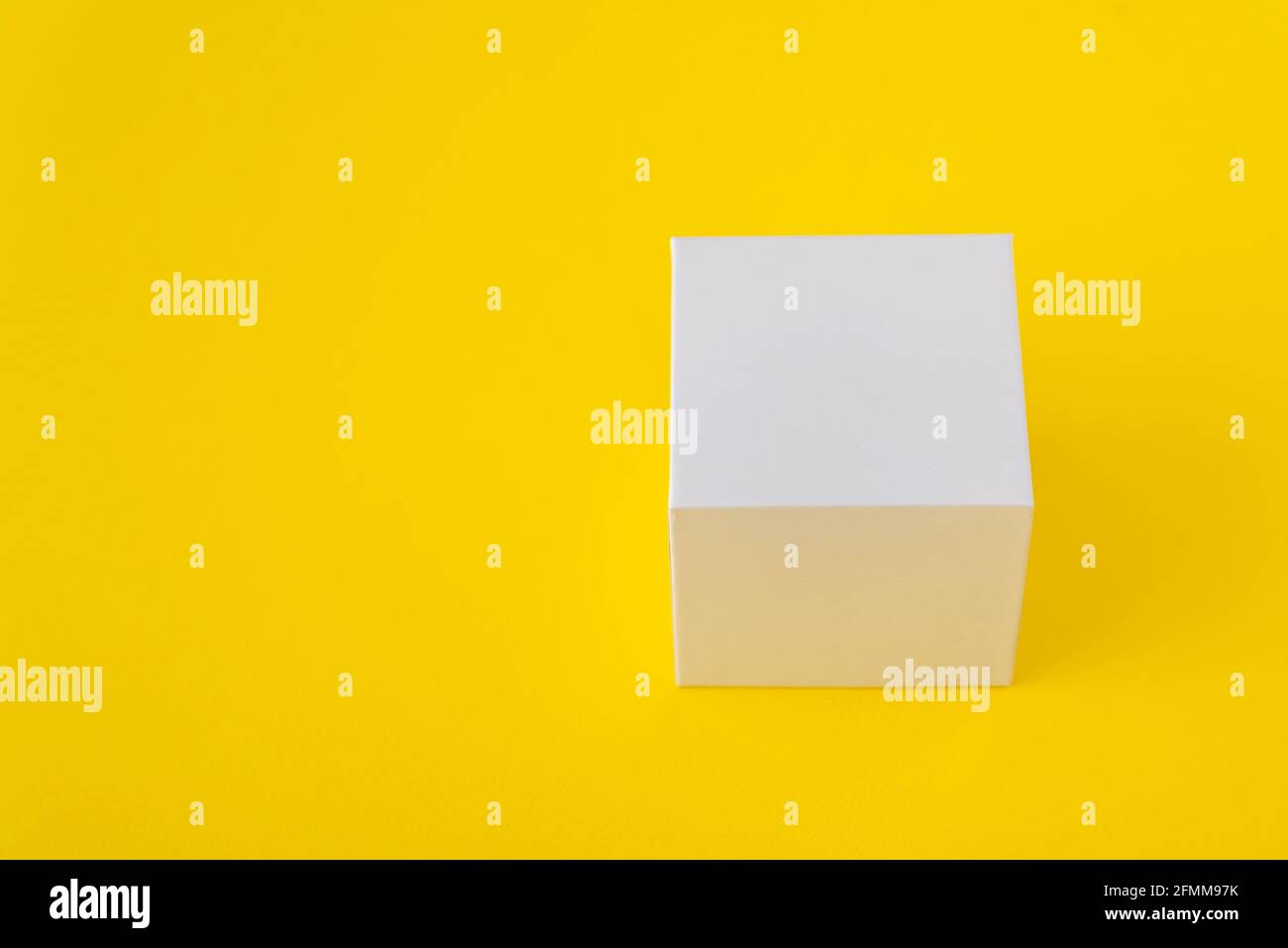 White square cardboard box on a yellow background. Side view. Copy ...