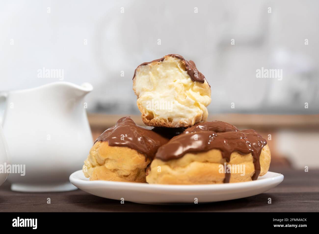 Cut eclair with cream poured with chocolate, close-up. Sweet dessert ...