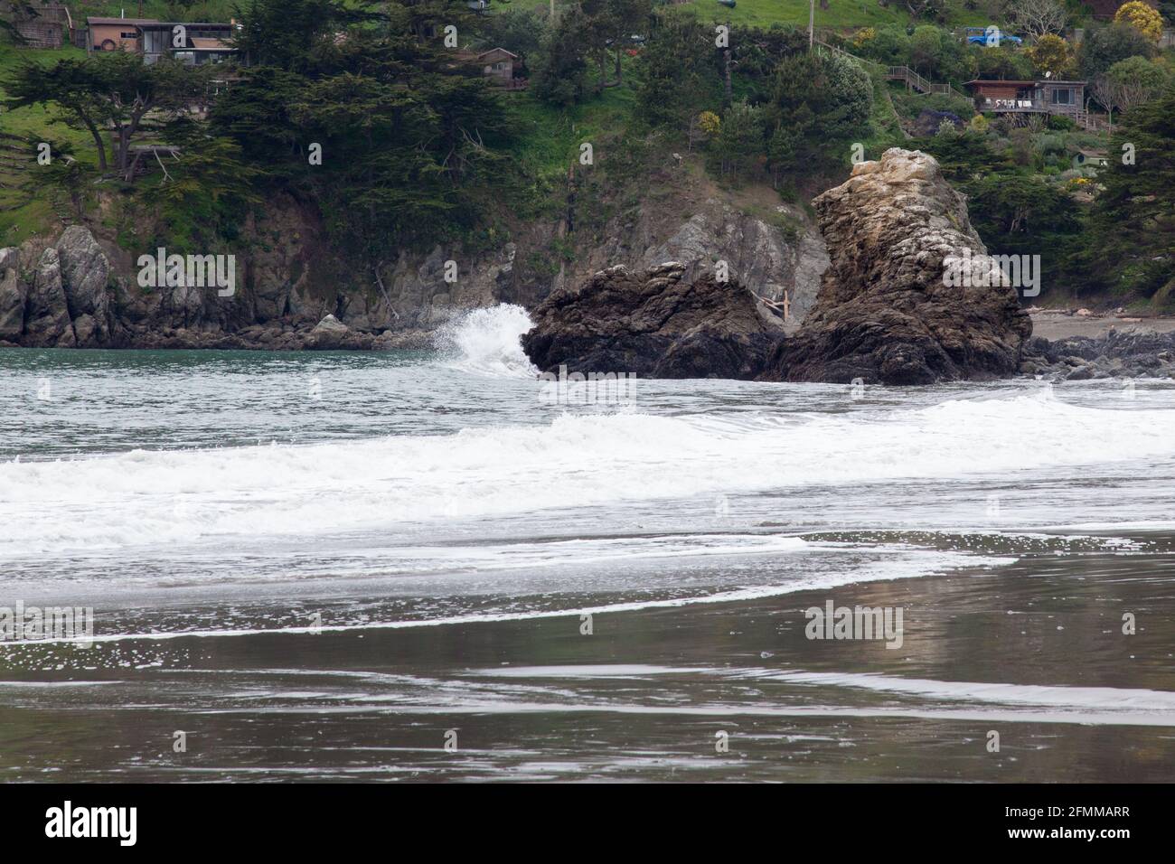 Ocean splashing on rocks at the shore Stock Photo - Alamy