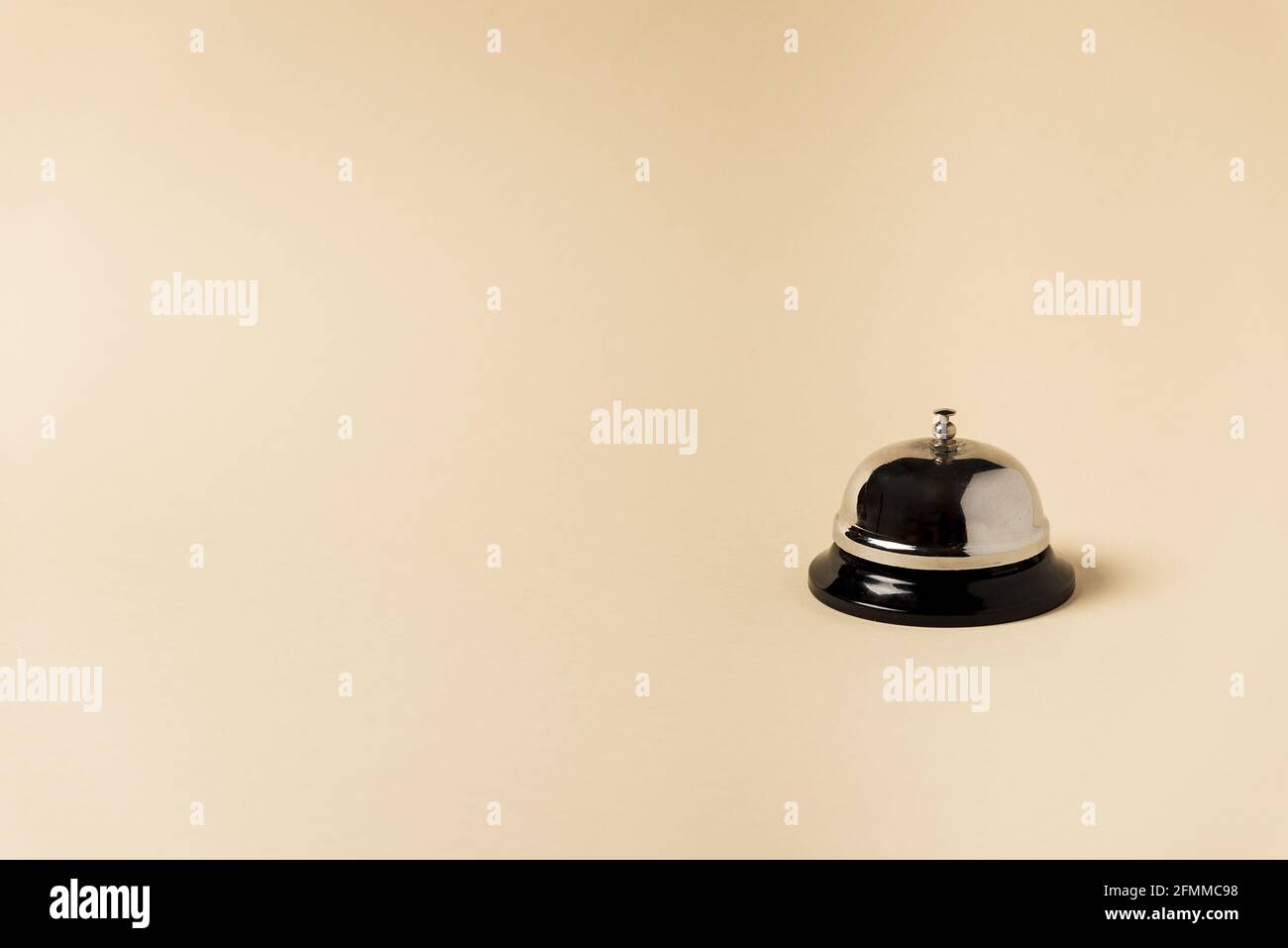 Silver hotel bell isolated on a beige background with free space for ...