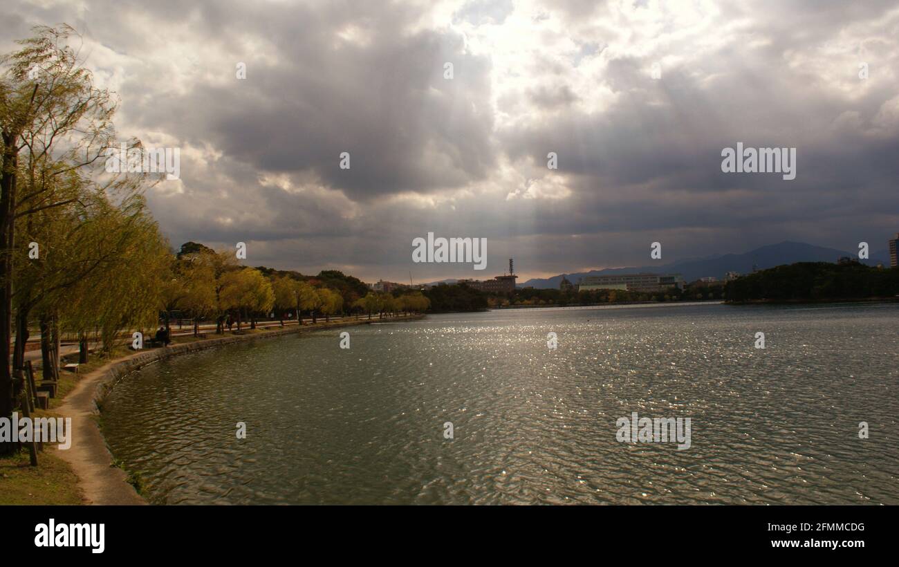 Fukuoka, Japan, November 2011: sunset with reflections on the city lake ...