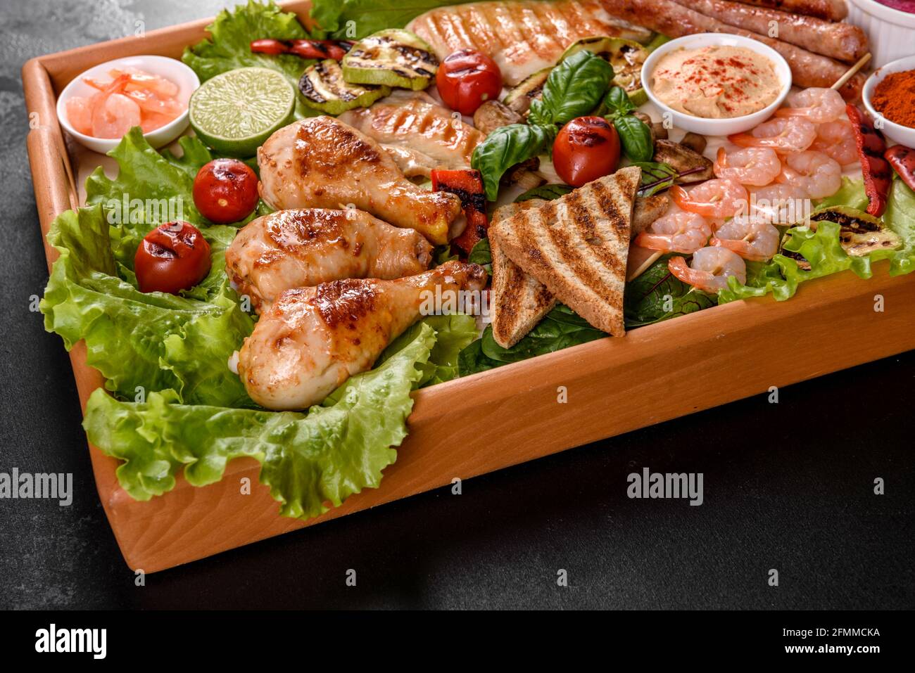 Composition of sausages, chicken, pork and shrimp prepared on grill, as ...