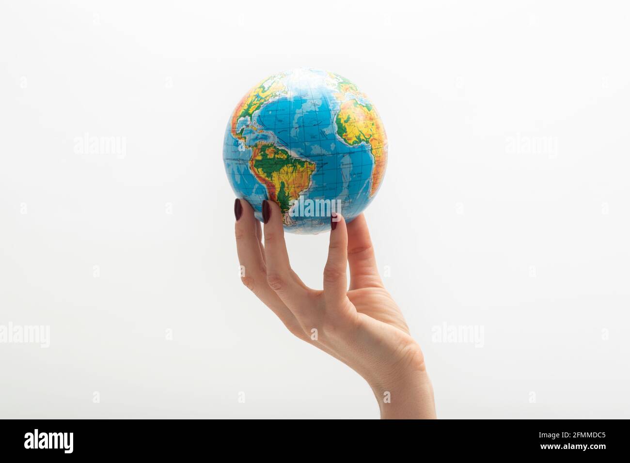 Globe at the tip of woman's fingers. Female hand holds globe. World in ...