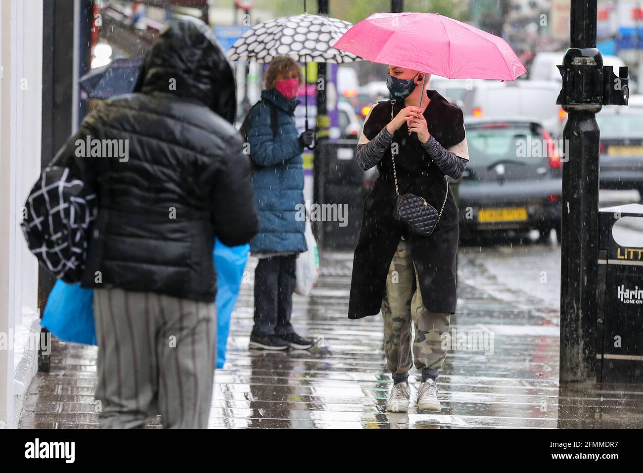 People shelter from rain beneath umbrellas in London Stock Photo - Alamy