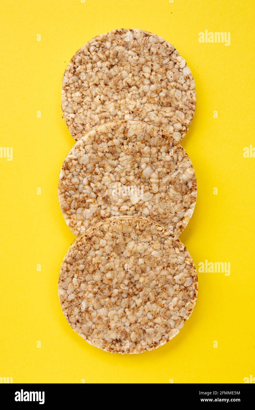 crunchy rice cakes on yellow background, three puffed whole grain ...