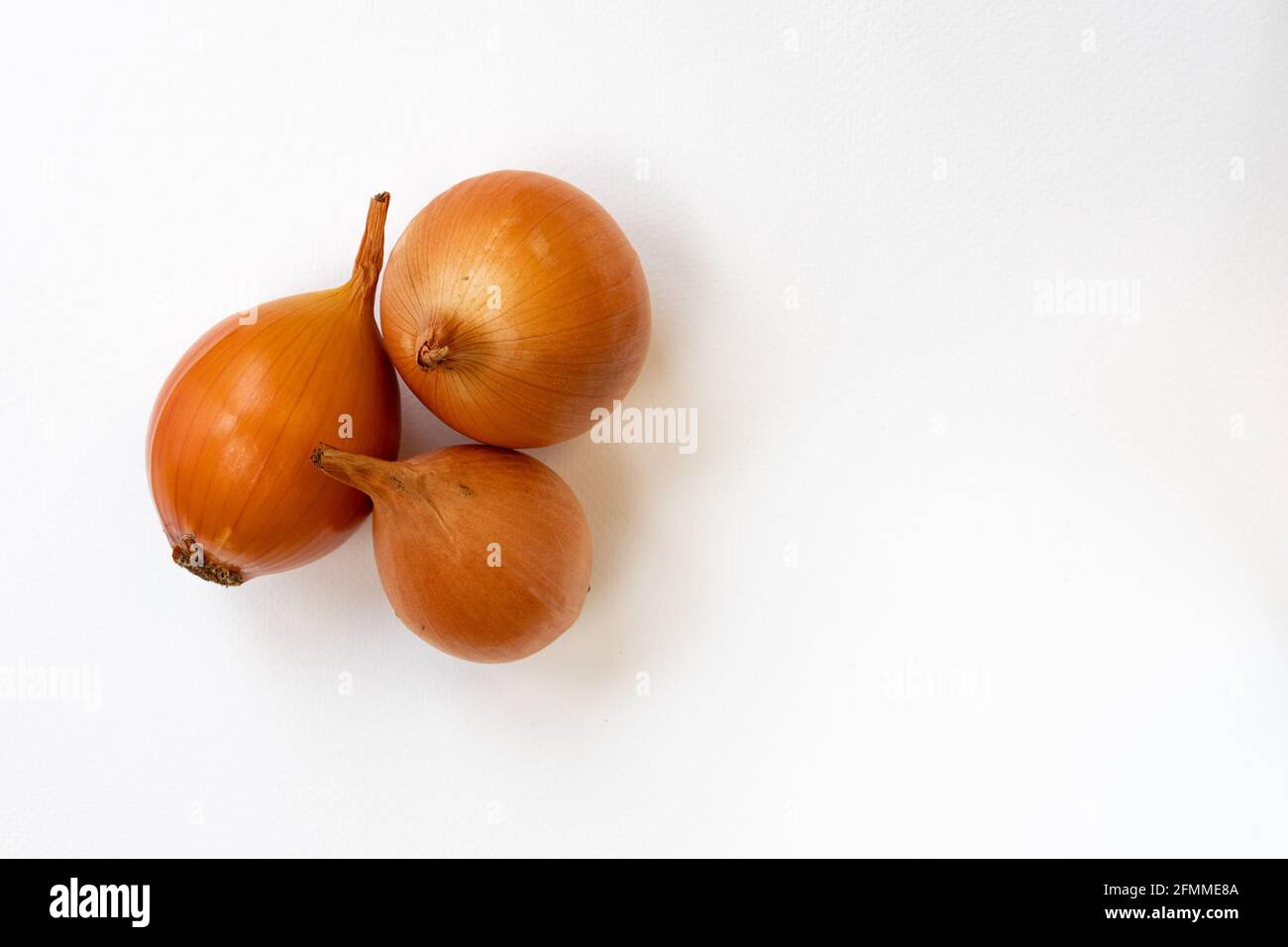close up three fresh onions isolated on white background, unpeeled ...