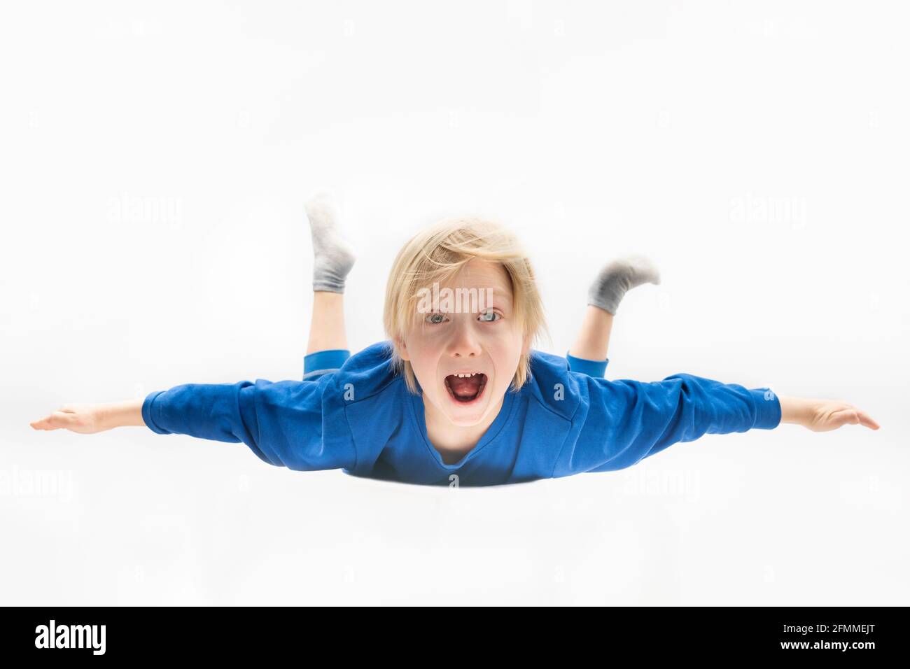 Surprised boy is flying or falling in the air. Free fall. White ...