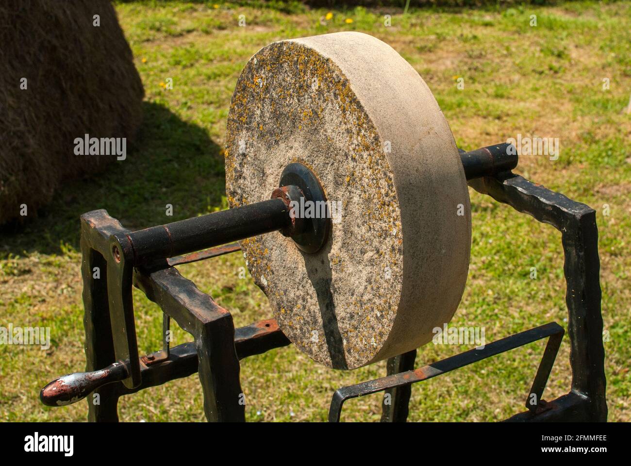 Old grinding sharpening whetstone manual wheel in rural house garden ...