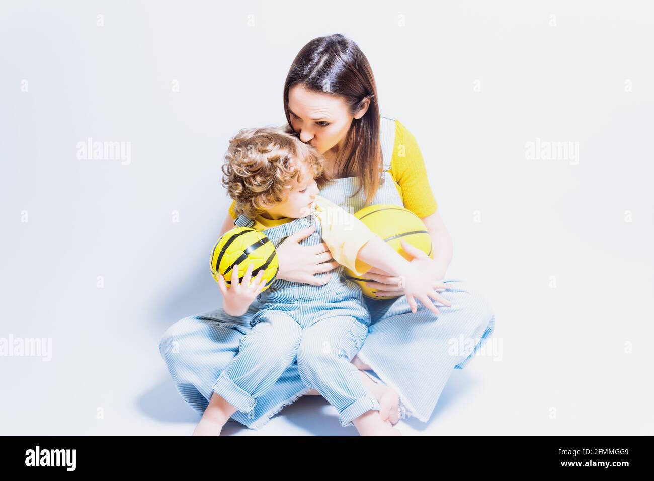 Single parent young adult mother playing with her son with a basketball ...