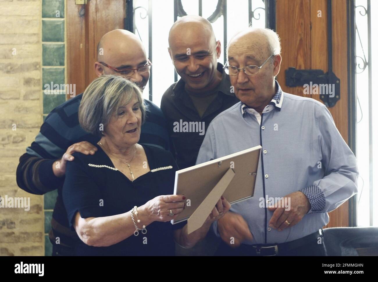 Beautiful happy Spanish family looking at the photo with proud and ...