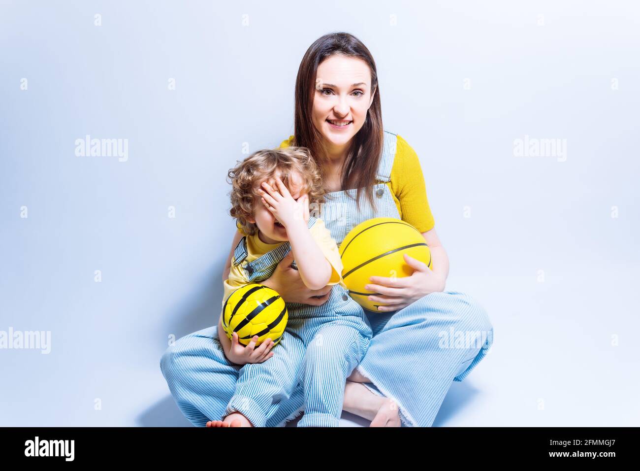 Single parent young adult mother playing with her son with a basketball ...