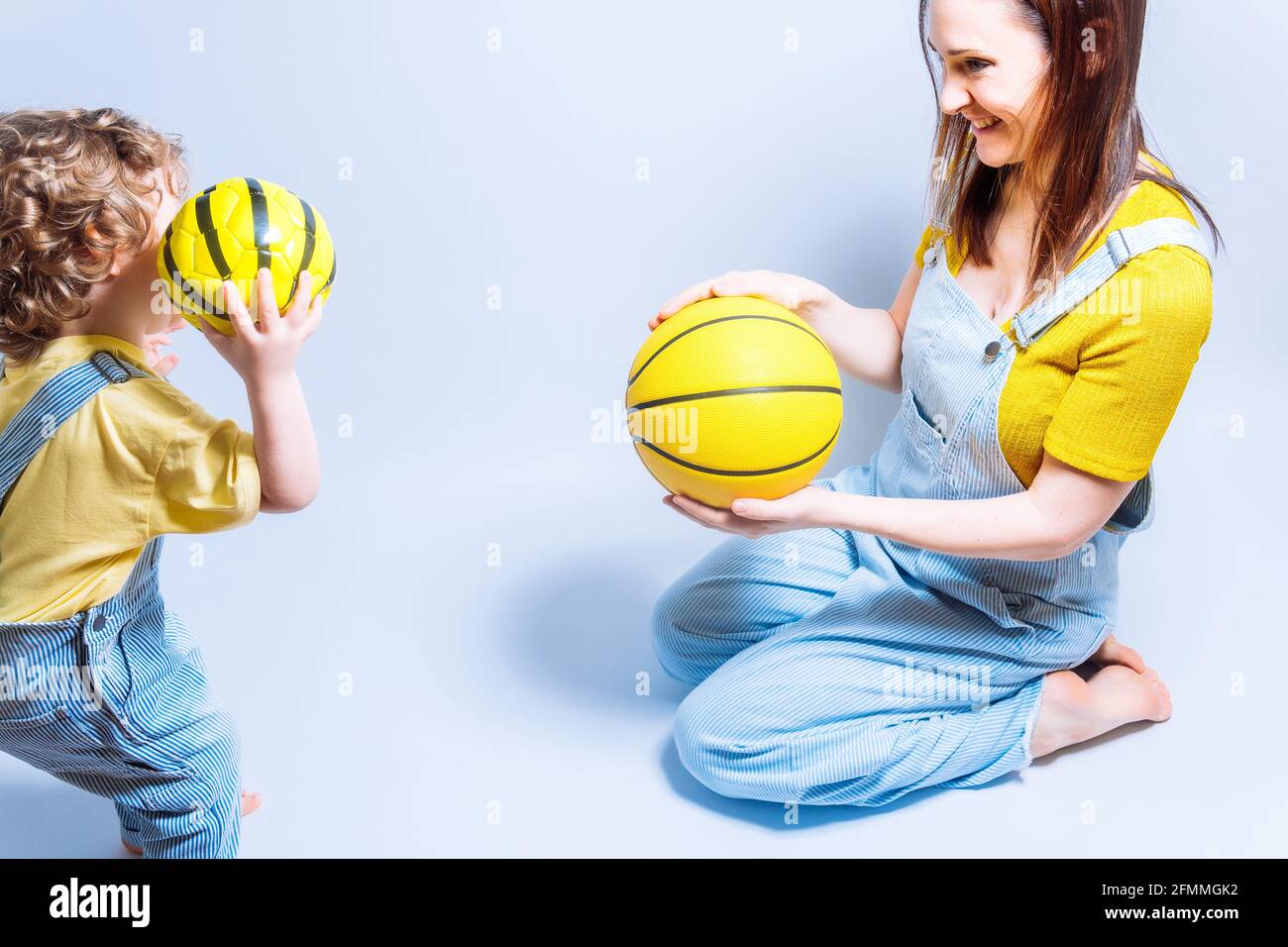 Single parent young adult mother playing with her son with a basketball ...