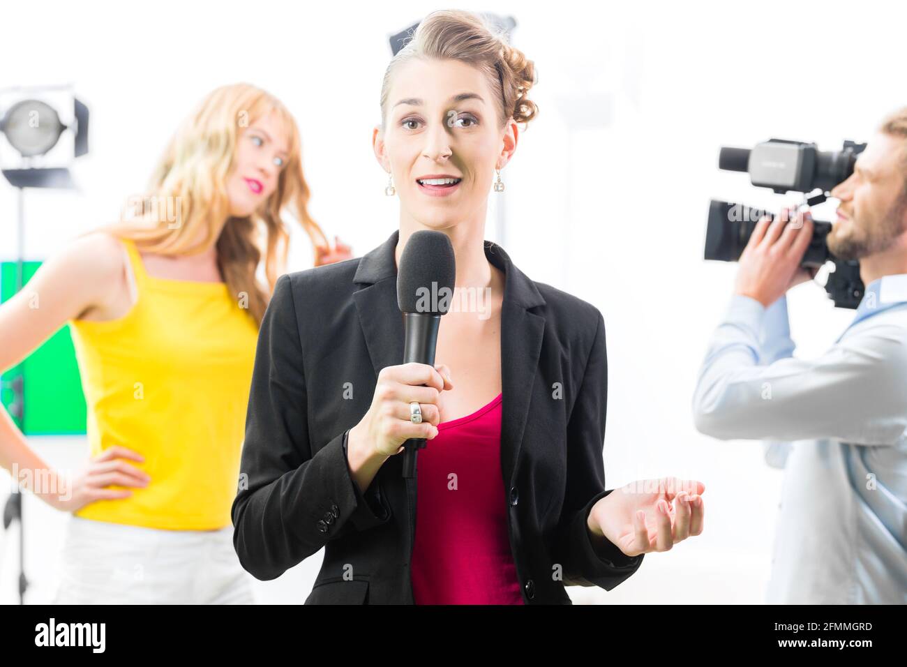 Reporter and cameraman shoot actress interview on film set for TV or ...