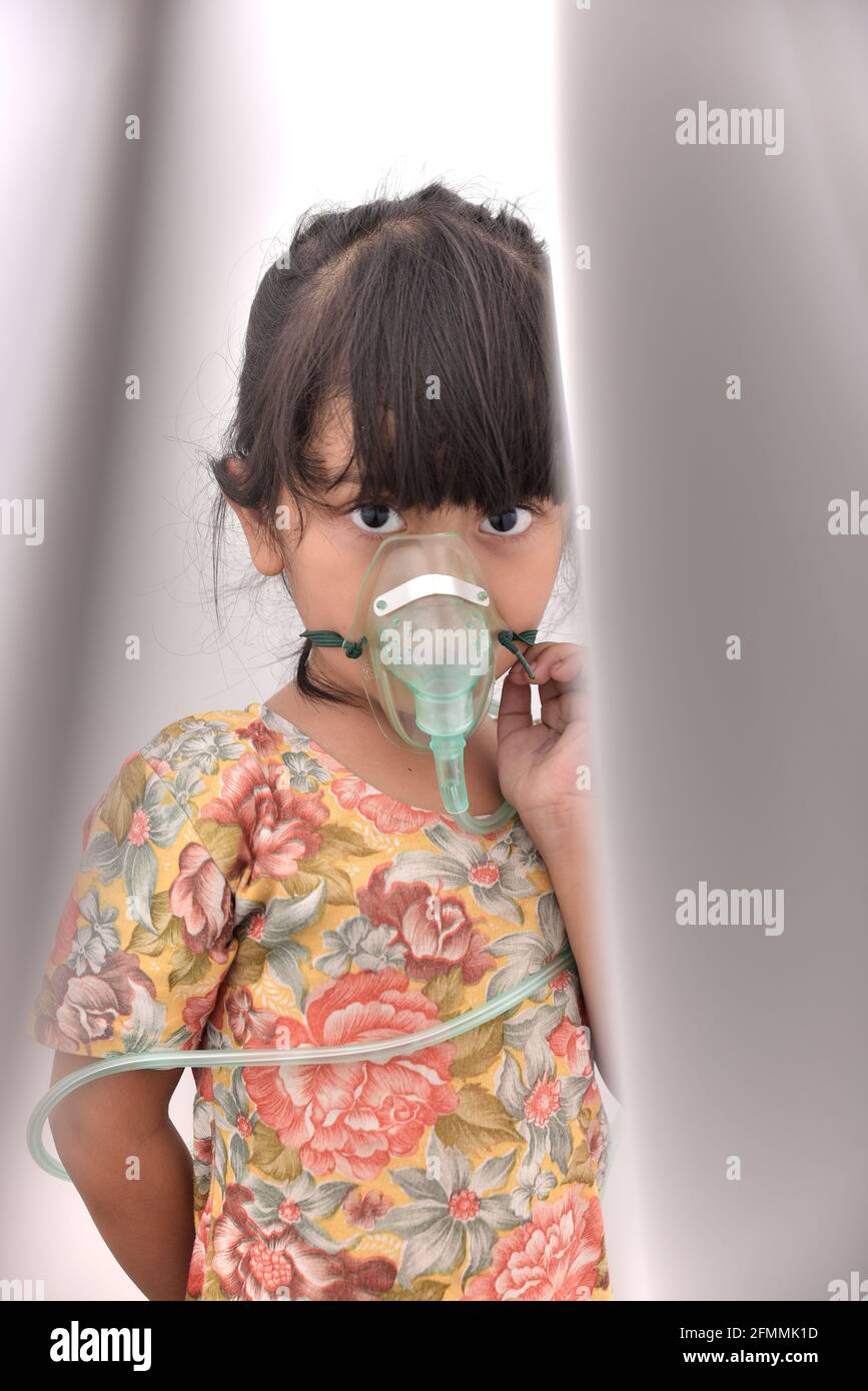 Little girl in a nebulizer mask, treatments for virus pandemic at home ...
