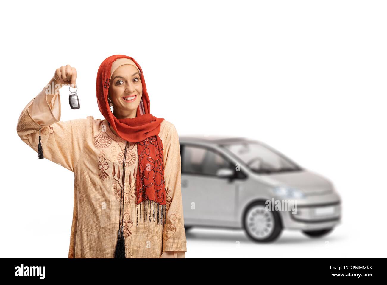 Young muslim woman holding a car key and smiling isolated on white ...