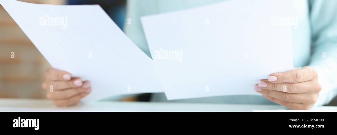 Female hands hold documents over work table Stock Photo - Alamy