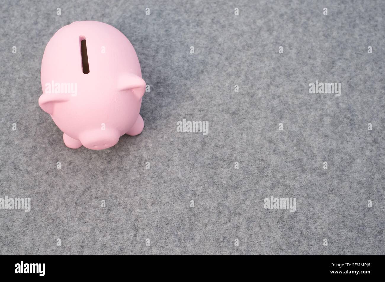 High angle shot of a cute piggy bank on a gray background with copy ...
