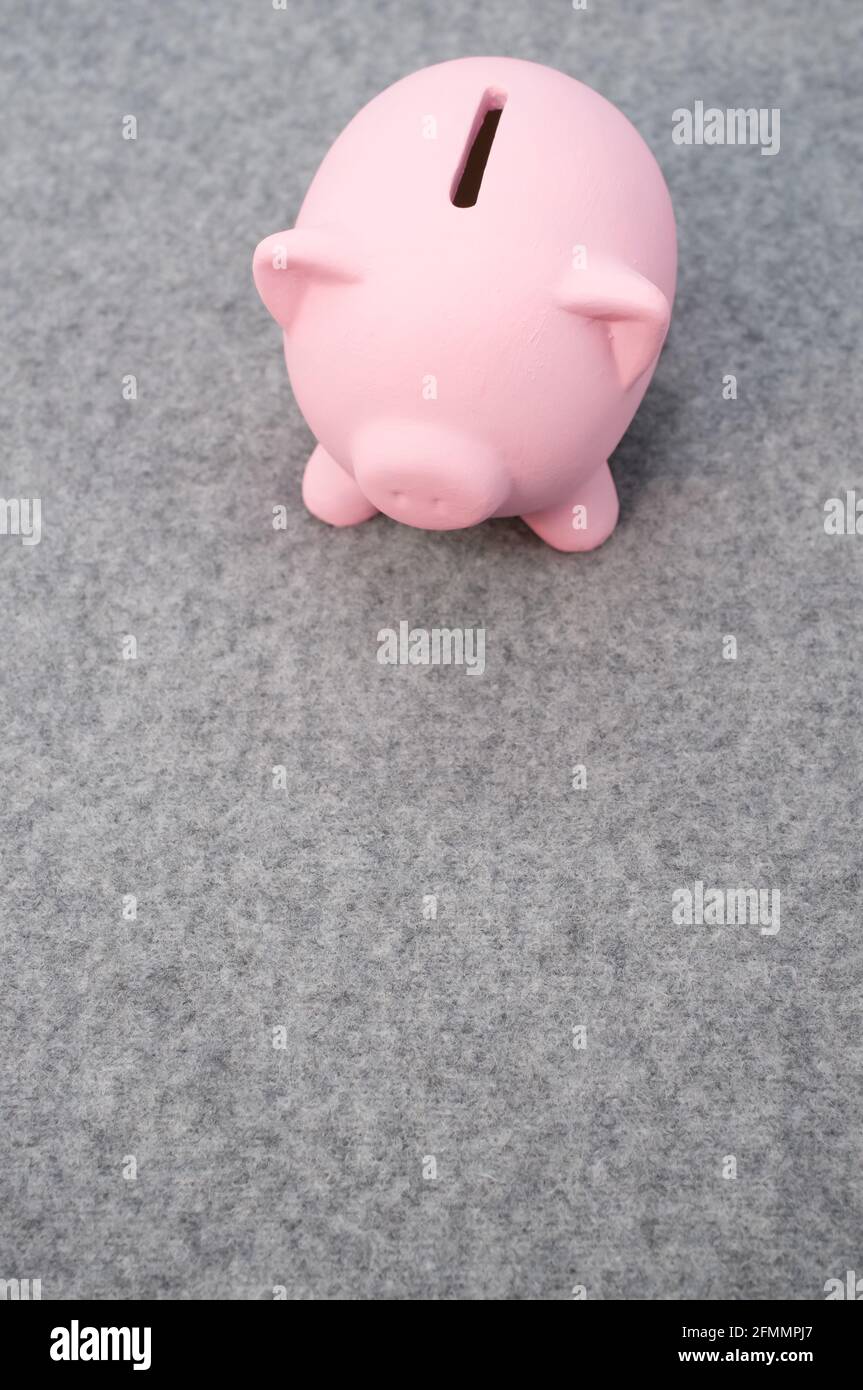 Cute simple pink piggy bank on a gray woolen background Stock Photo - Alamy