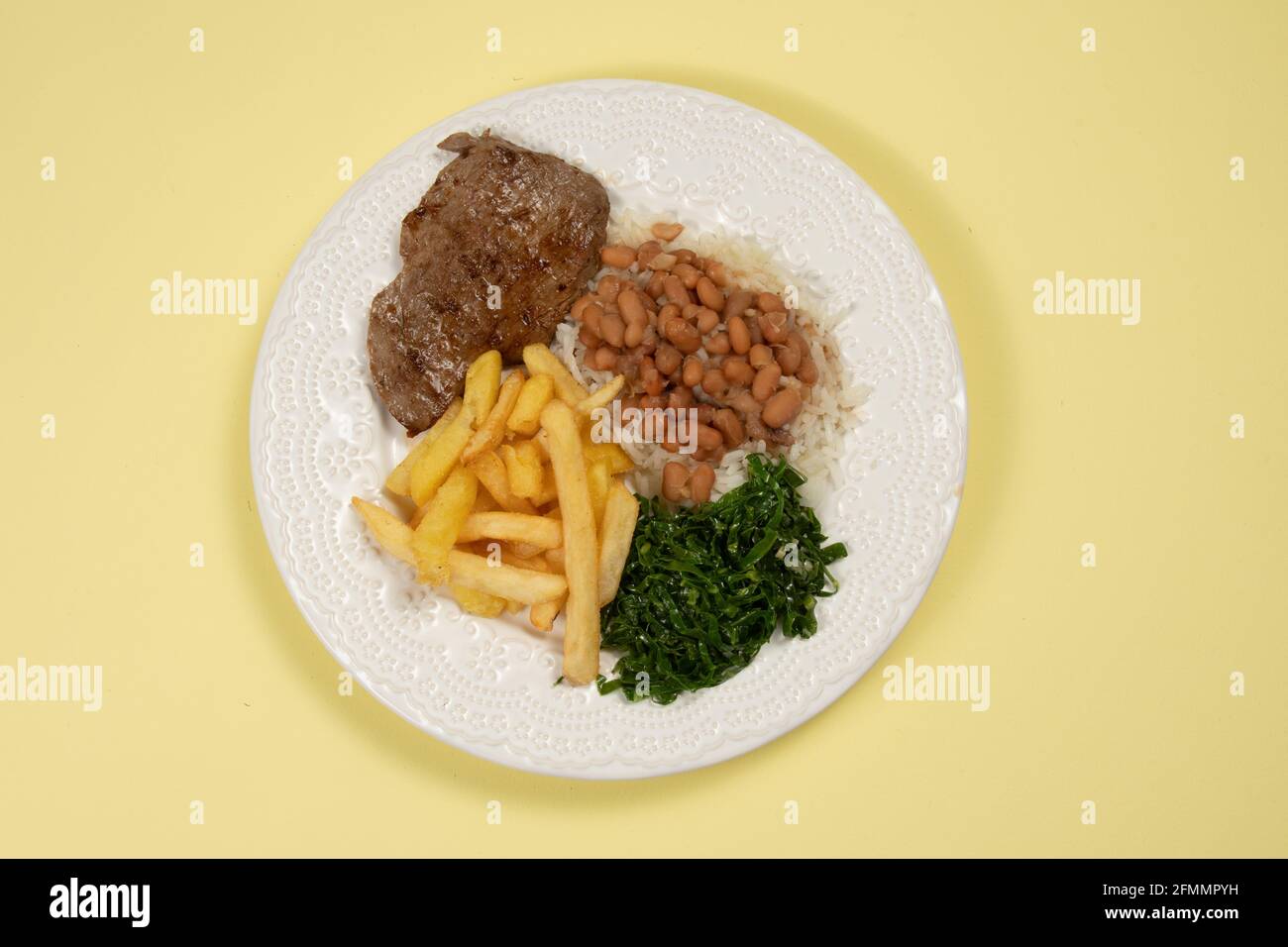 typical Brazilian basic dish with rice, beans, steak, french fries and ...