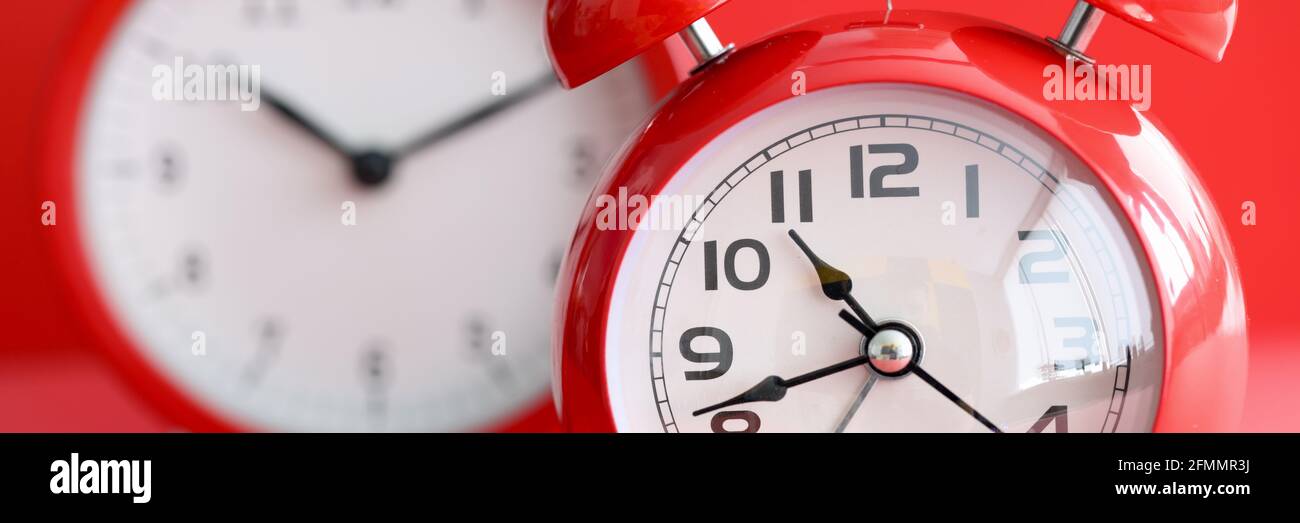 Two red alarm clocks with different times Stock Photo - Alamy