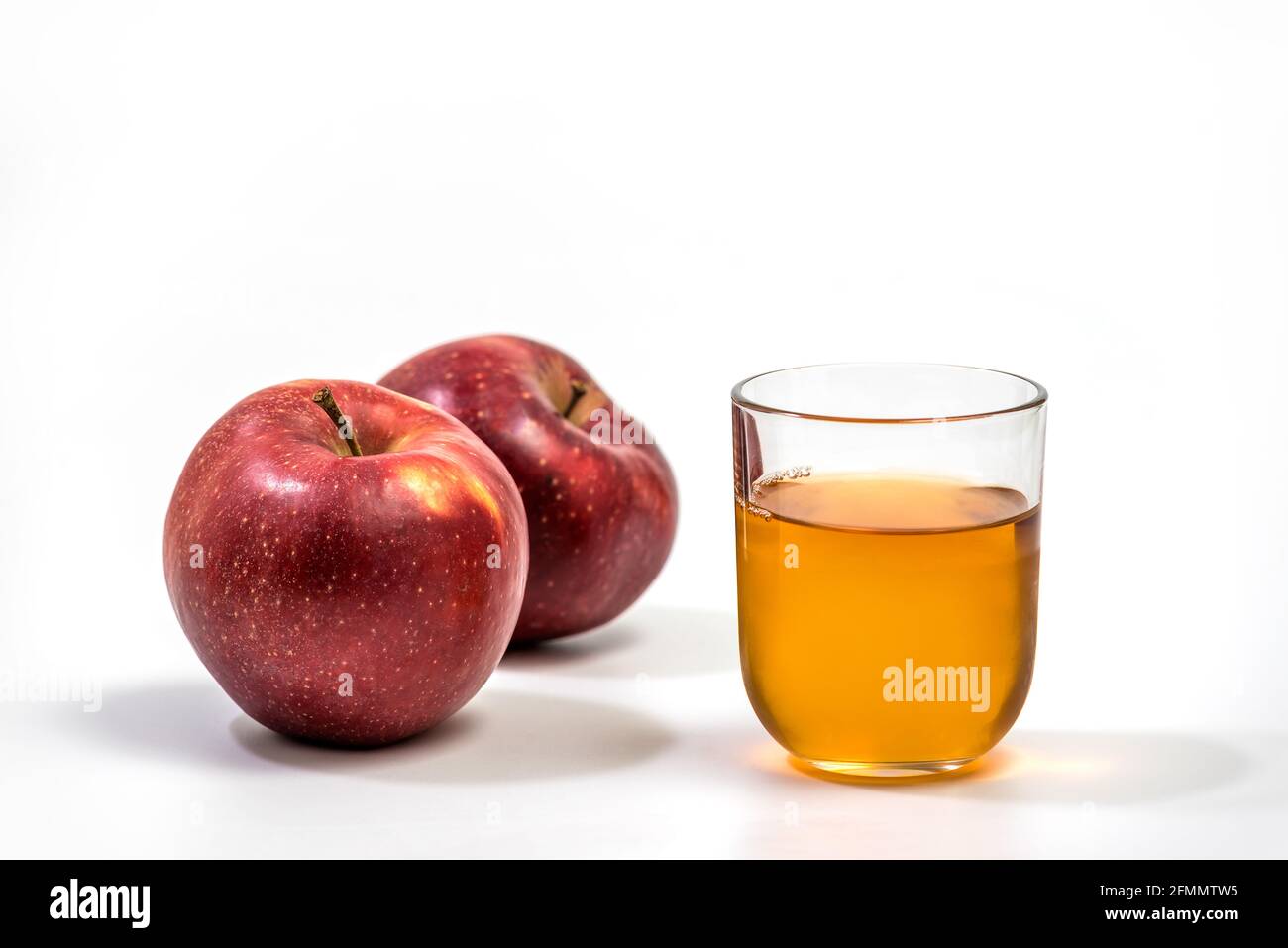Close up of a glass of apple juice, with a whole and half apple ...