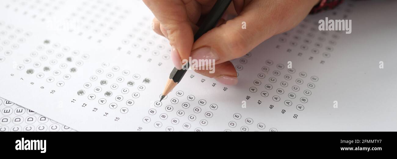 Female hand holds pencil and marks answers to test Stock Photo - Alamy