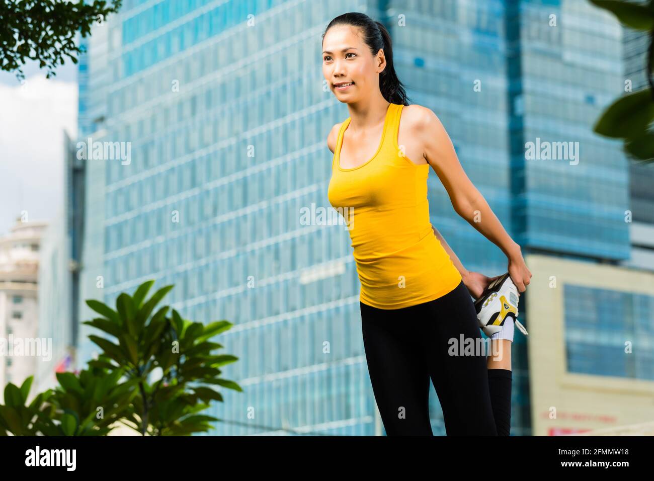 Urban sports - Asian Indonesian woman doing fitness in the city on a ...