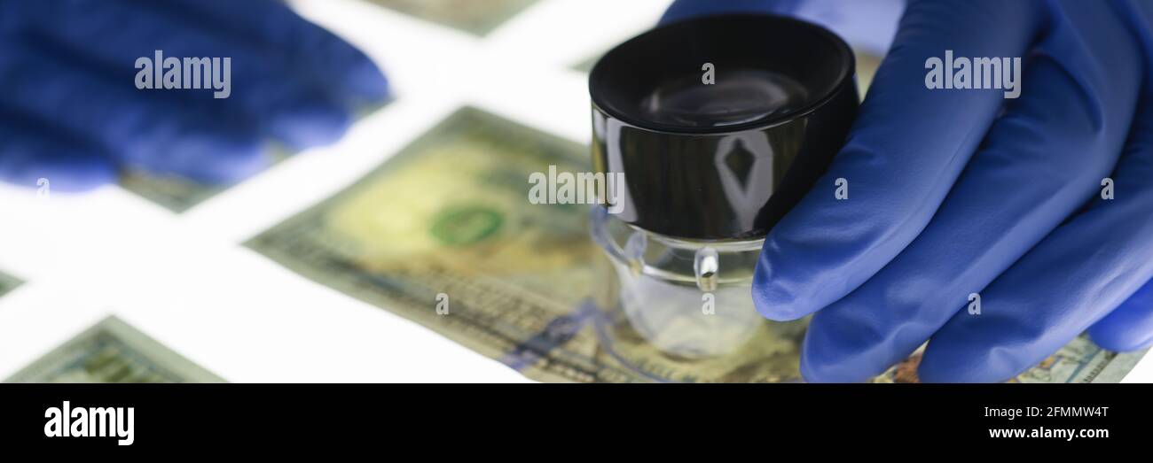 Expert checks authenticity of banknotes. Counterfeiting and types of ...