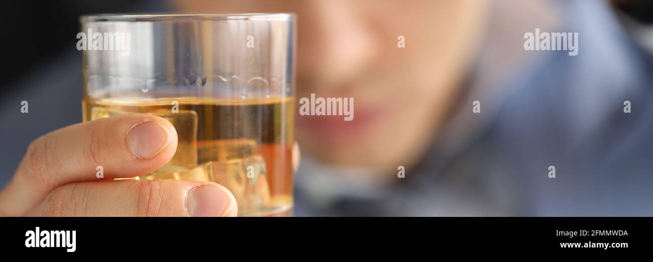 Man holds glass of alcohol in his hands Stock Photo - Alamy
