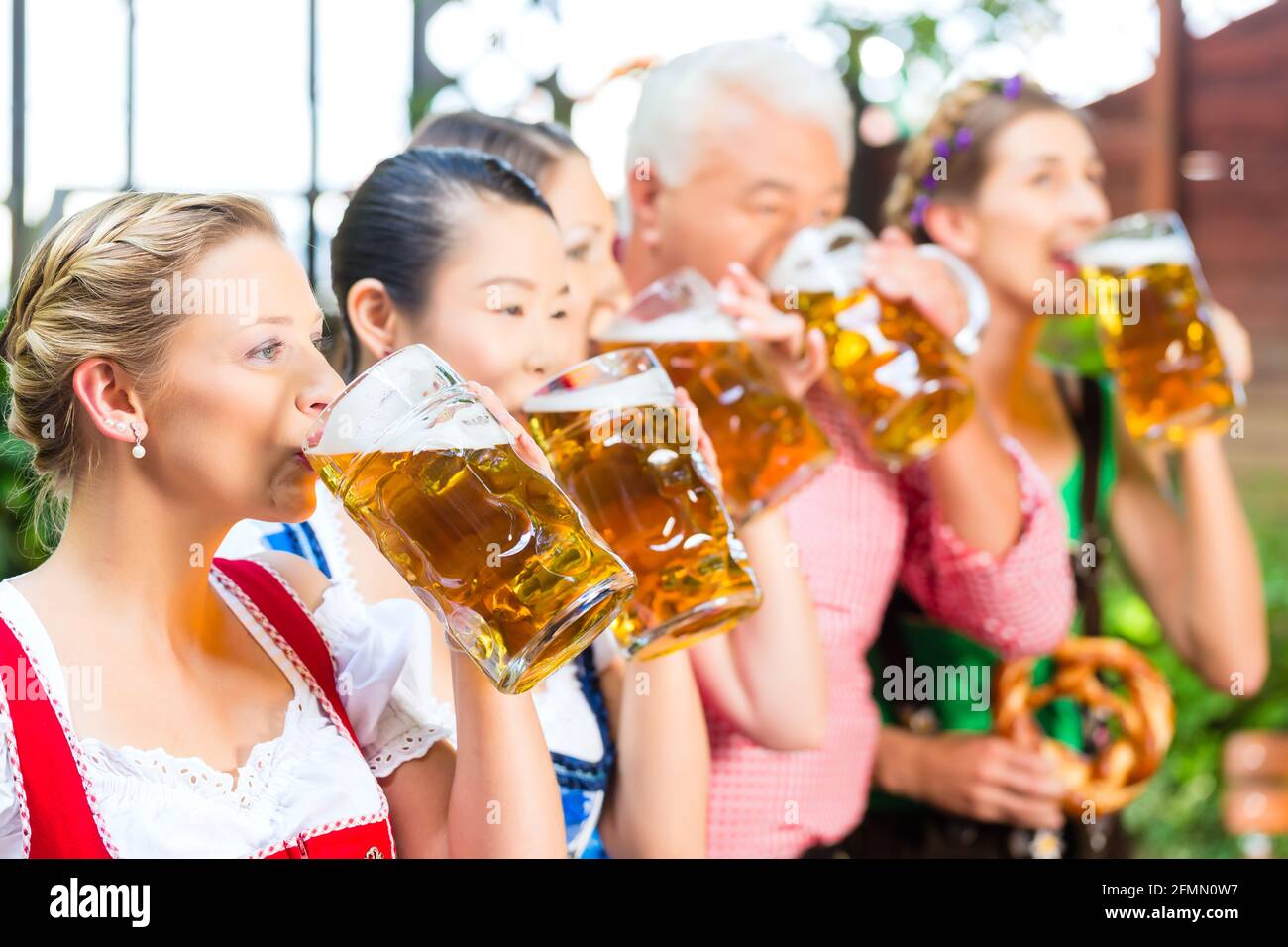 In Beer garden - friends, man and women in Tracht, Dirndl and ...