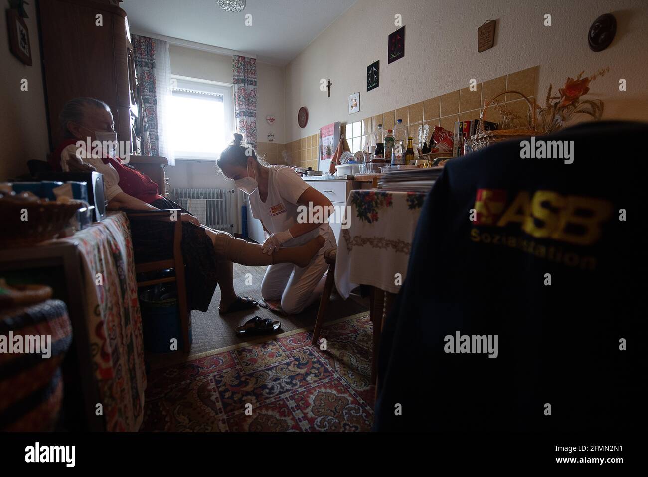 Karben, Germany. 10th May, 2021. Anna Hahn (r), nursing assistant, puts ...