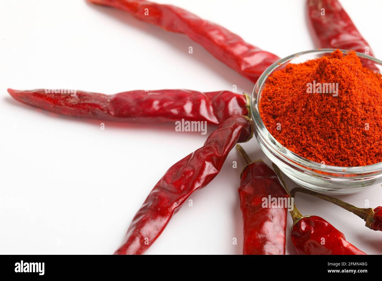 Dried red chilli and powder in glass bowl on white background Stock ...