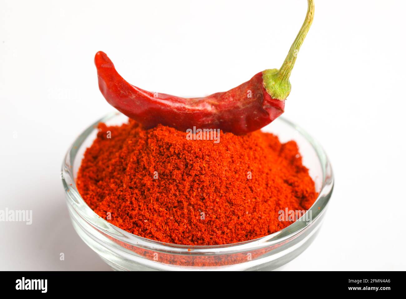 Dried red chilli and powder in glass bowl on white background Stock ...