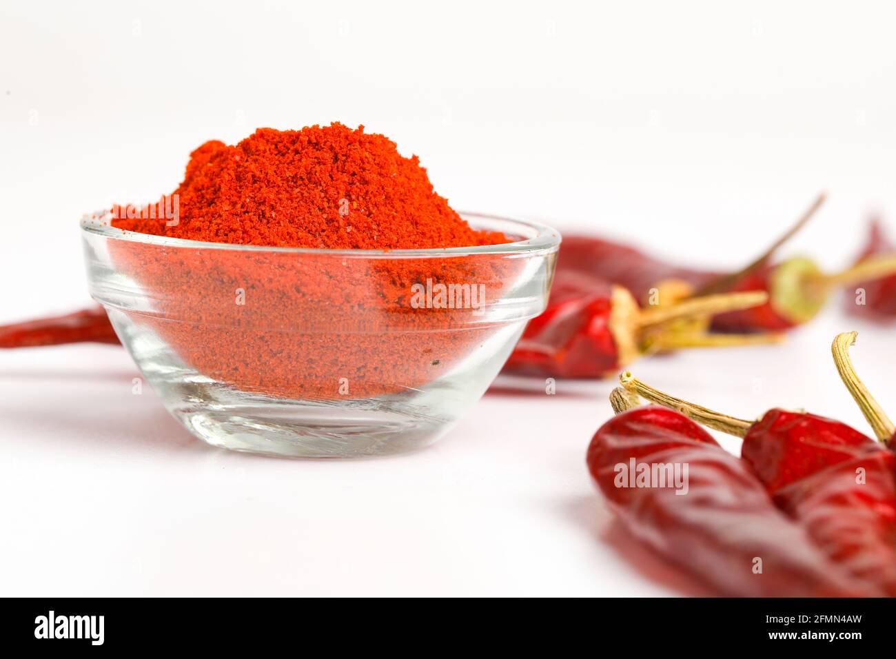 Dried red chilli and powder in glass bowl on white background Stock ...