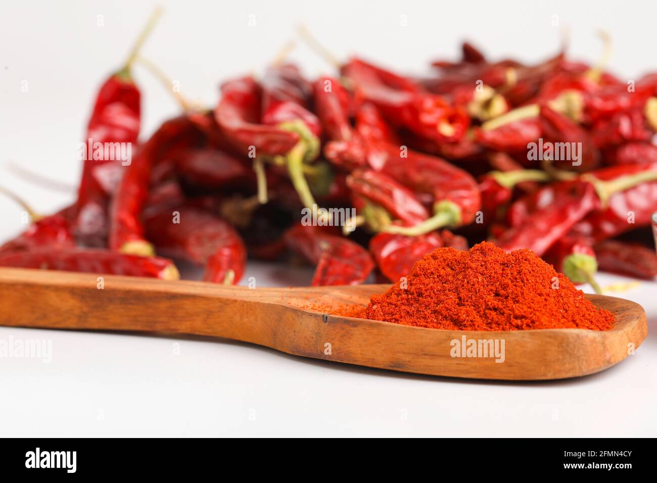 Dried red chilli and powder in wooden spoon on white background Stock ...