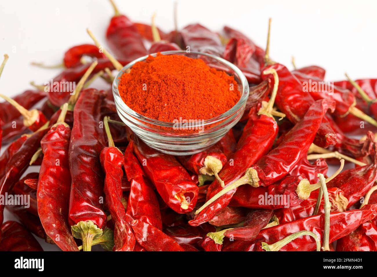 Dried red chilli and powder in glass bowl on white background Stock ...