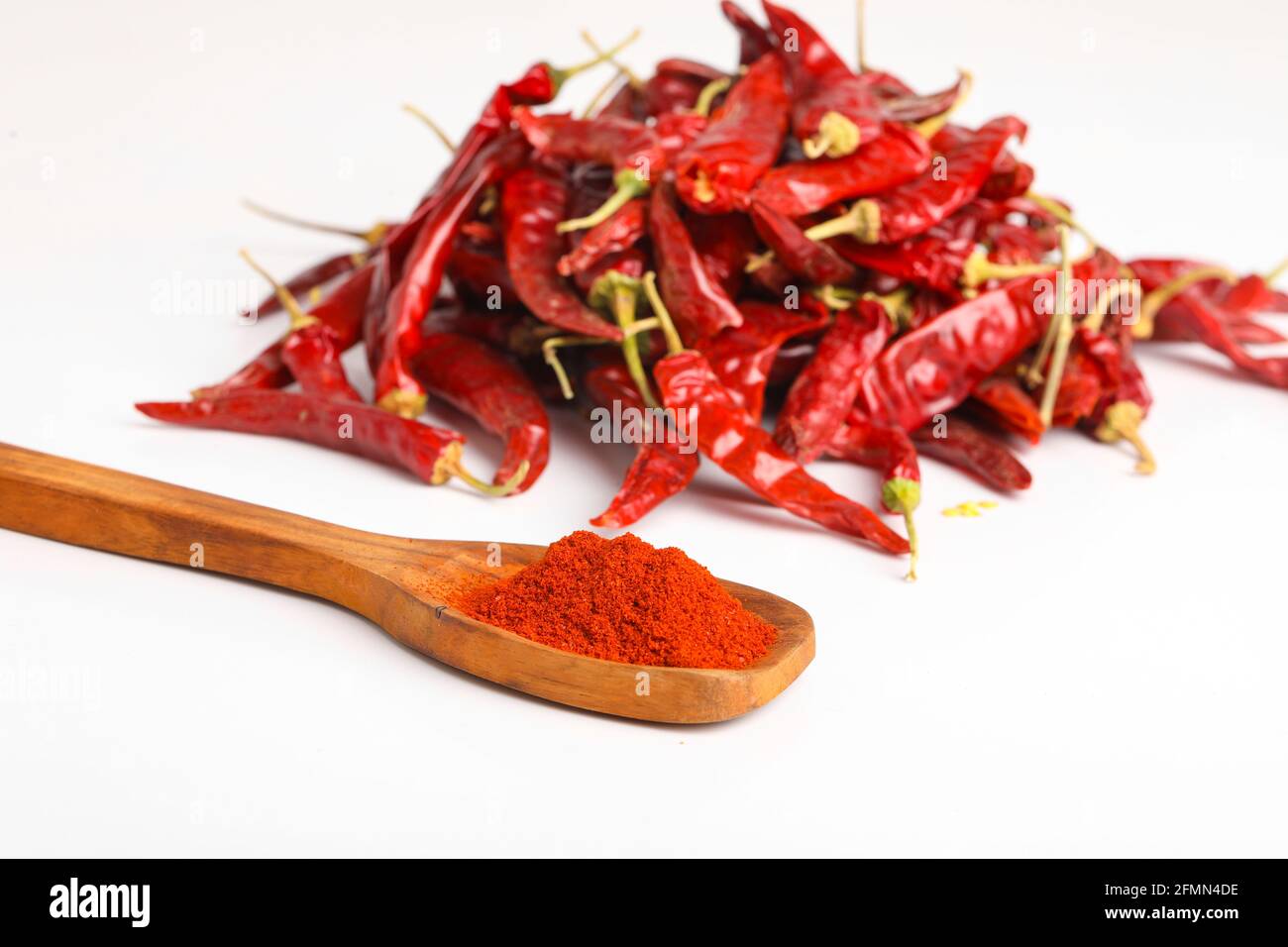 Dried red chilli and powder in wooden spoon on white background Stock ...