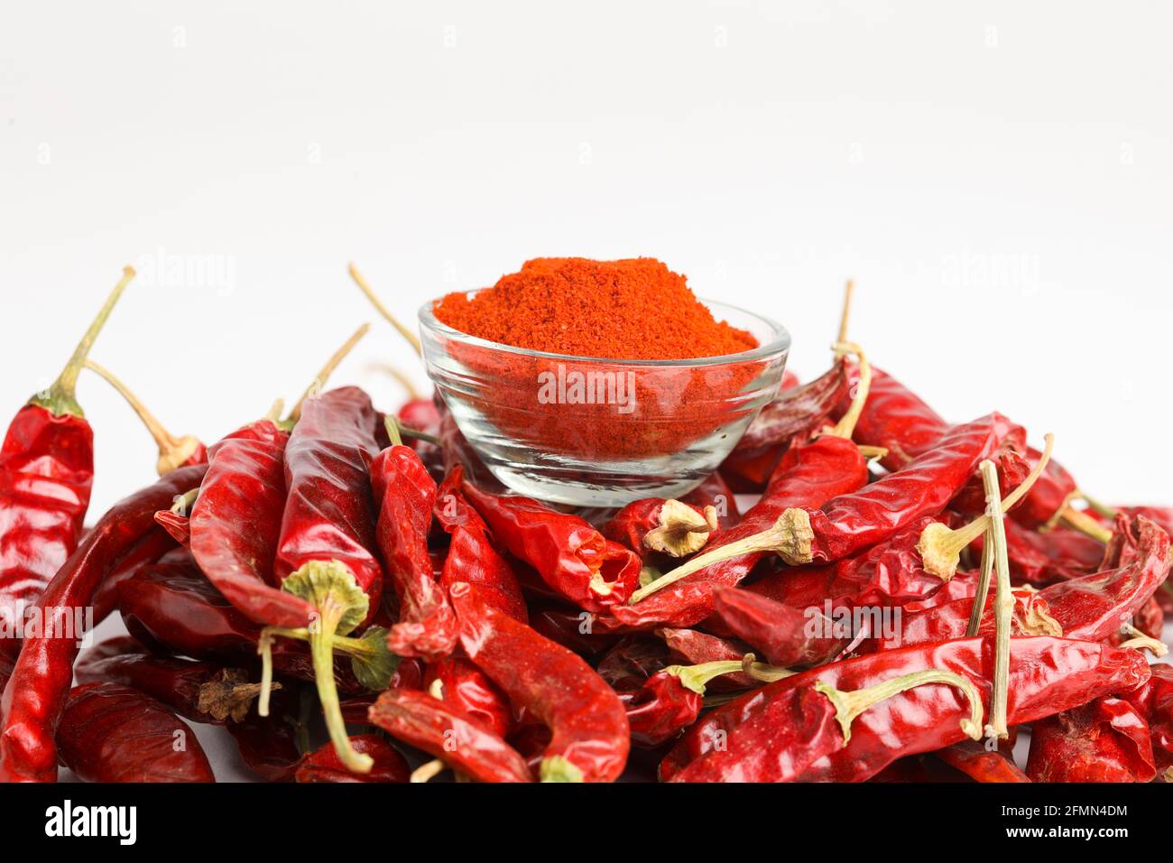 Dried red chilli and powder in glass bowl on white background Stock ...