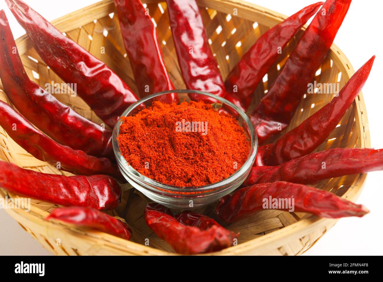 Dried red chilli and red chilli powder in glass bowl and wooden spoon ...