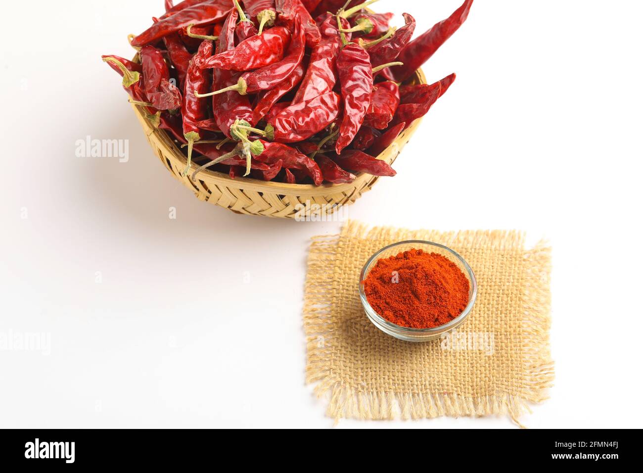 Dried red chilli and red chilli powder in glass bowl and wooden spoon ...
