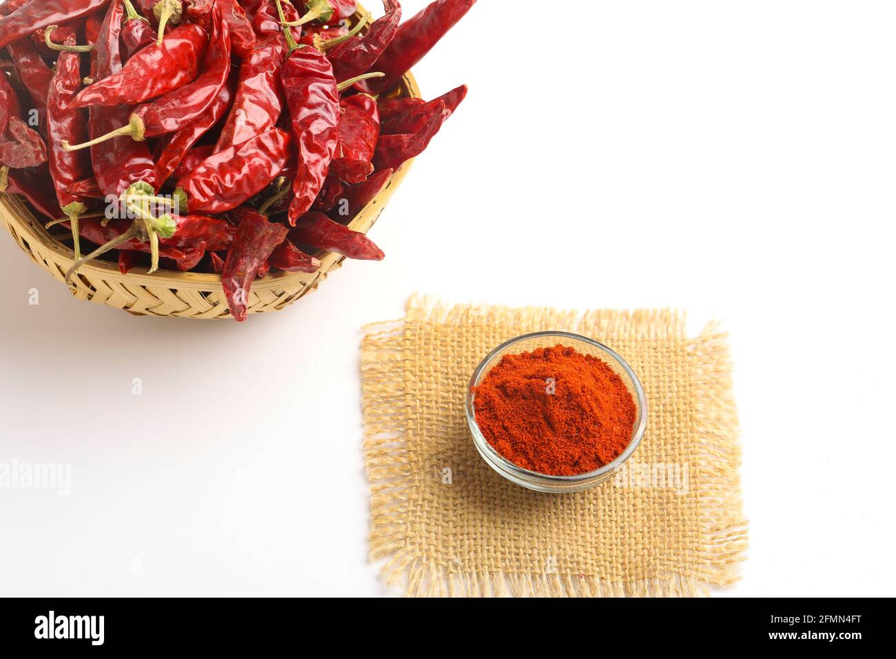 Dried red chilli and red chilli powder in glass bowl and wooden spoon ...