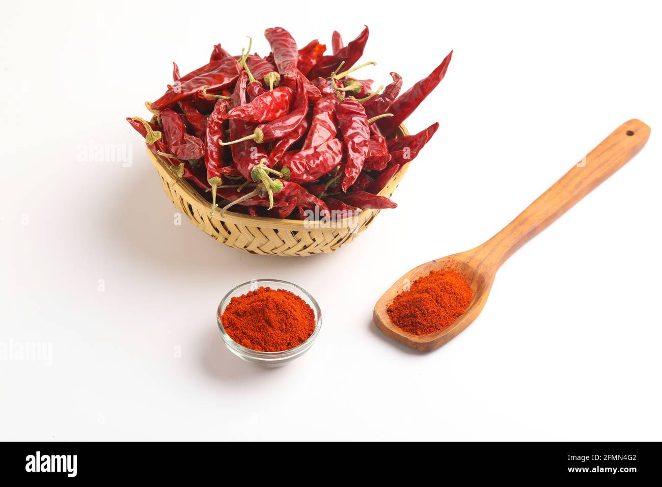 Dried red chilli and red chilli powder in glass bowl and wooden spoon ...