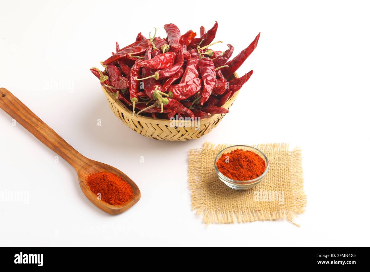 Dried red chilli and red chilli powder in glass bowl and wooden spoon ...