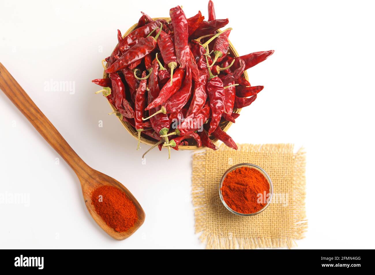 Dried red chilli and red chilli powder in glass bowl and wooden spoon ...