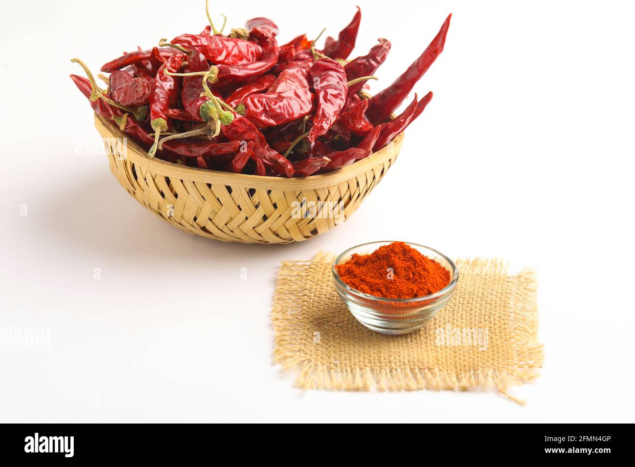Dried red chilli and red chilli powder in glass bowl and wooden spoon ...