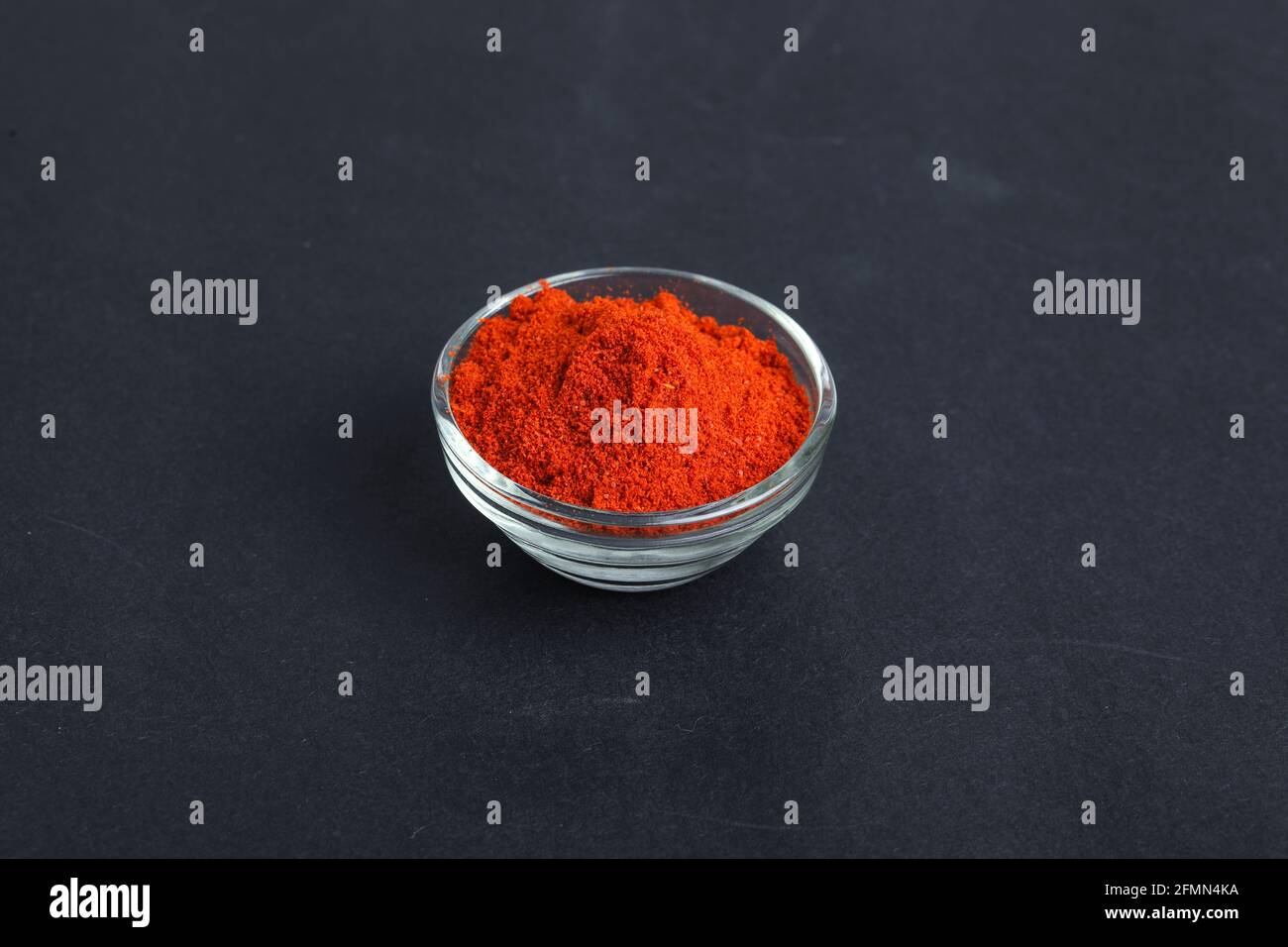 Dried red chilli and powder in glass bowl on dark background Stock ...