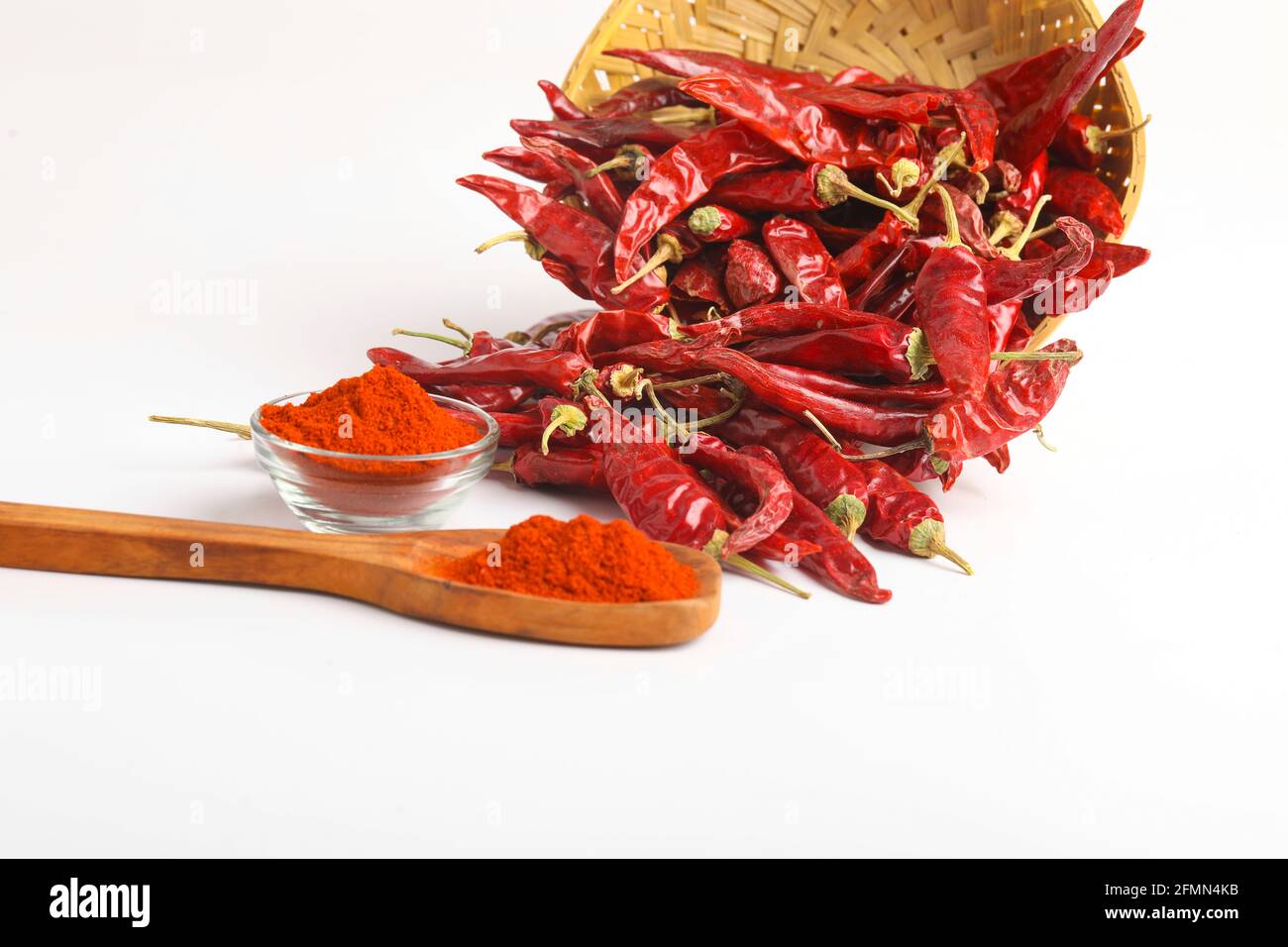 Dried red chilli and red chilli powder in glass bowl and wooden spoon ...