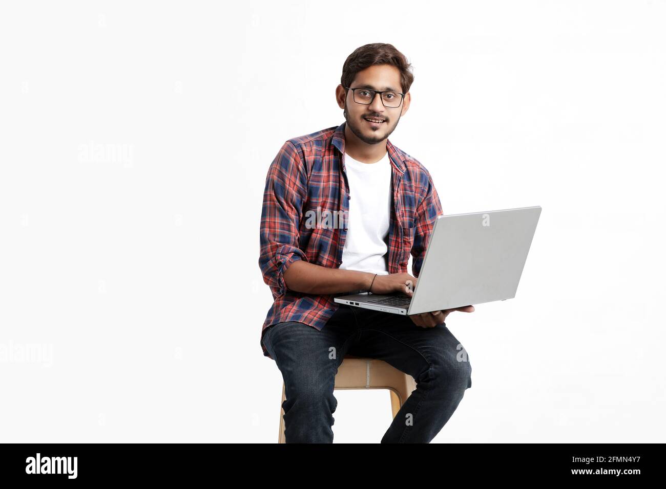 Indian college student using laptop on white background Stock Photo - Alamy